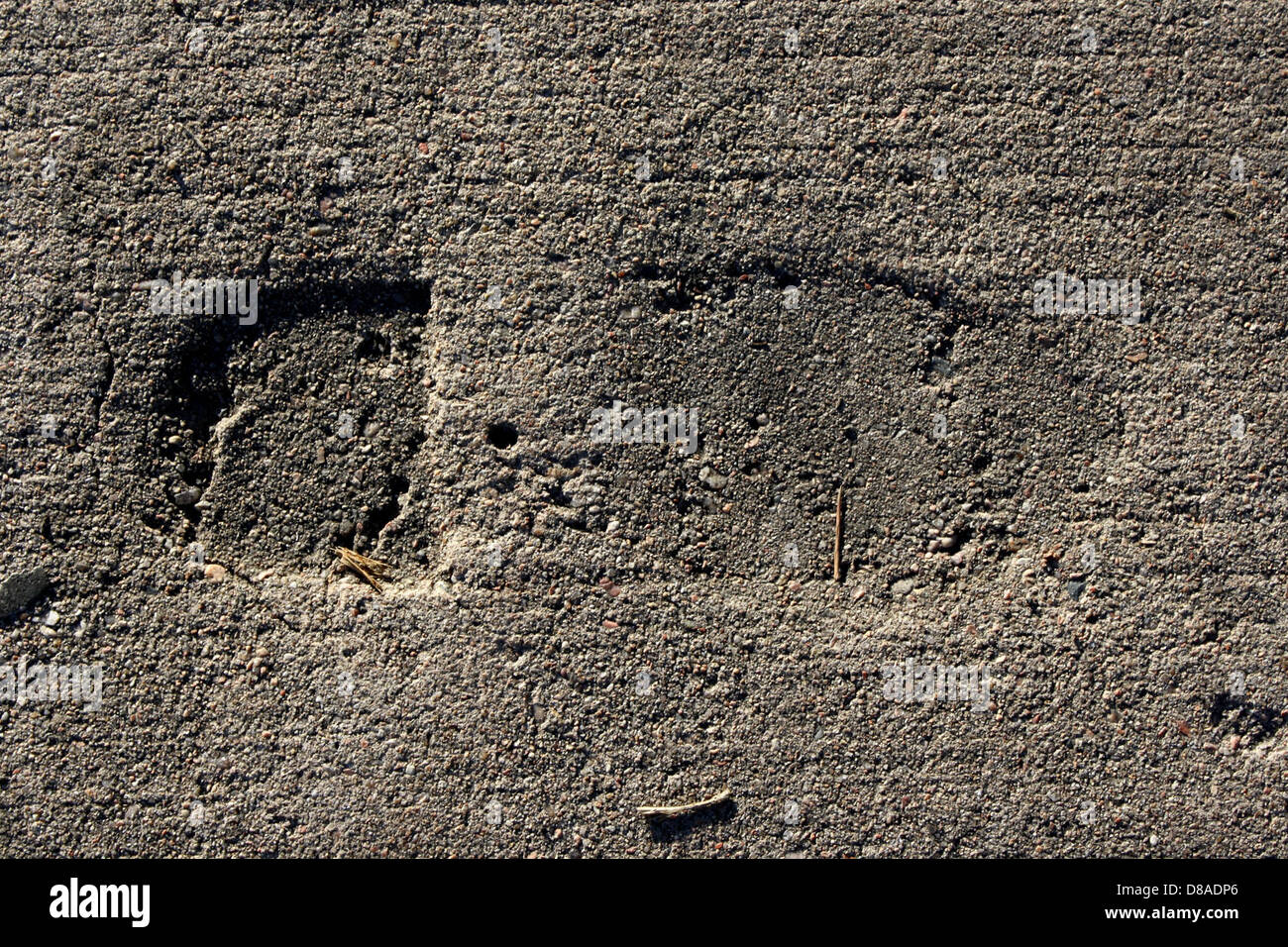 An image showing a clear footprint pressed into wet cement, capturing a ...