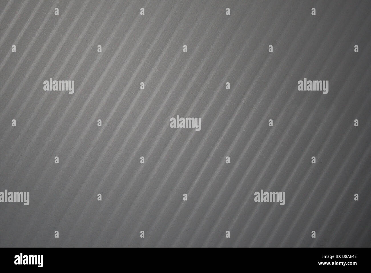 A close-up view of a gray plastic surface with diagonal stripes. The ...