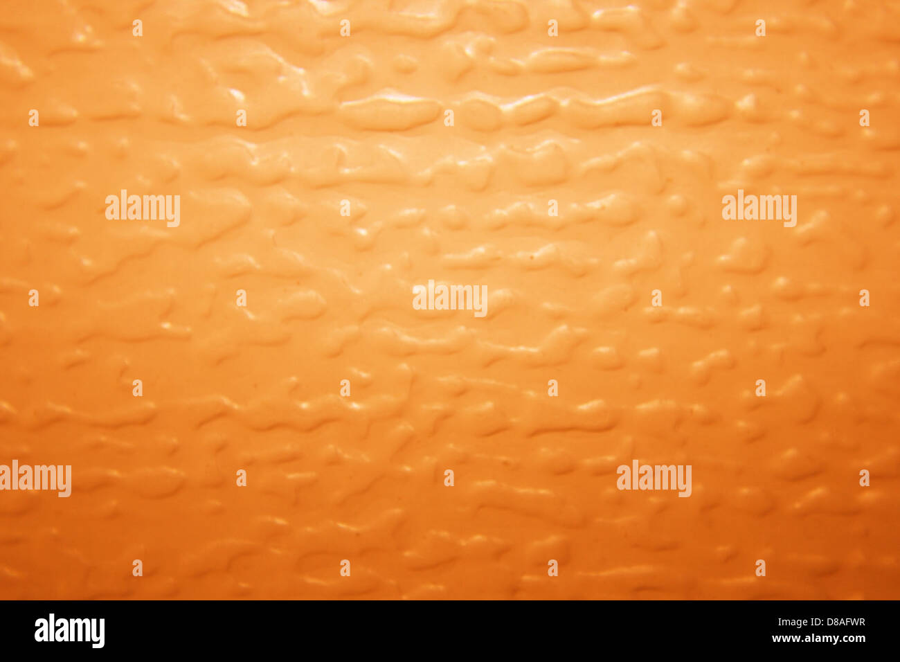 An image of orange plastic with a bumpy, textured surface. The bright ...