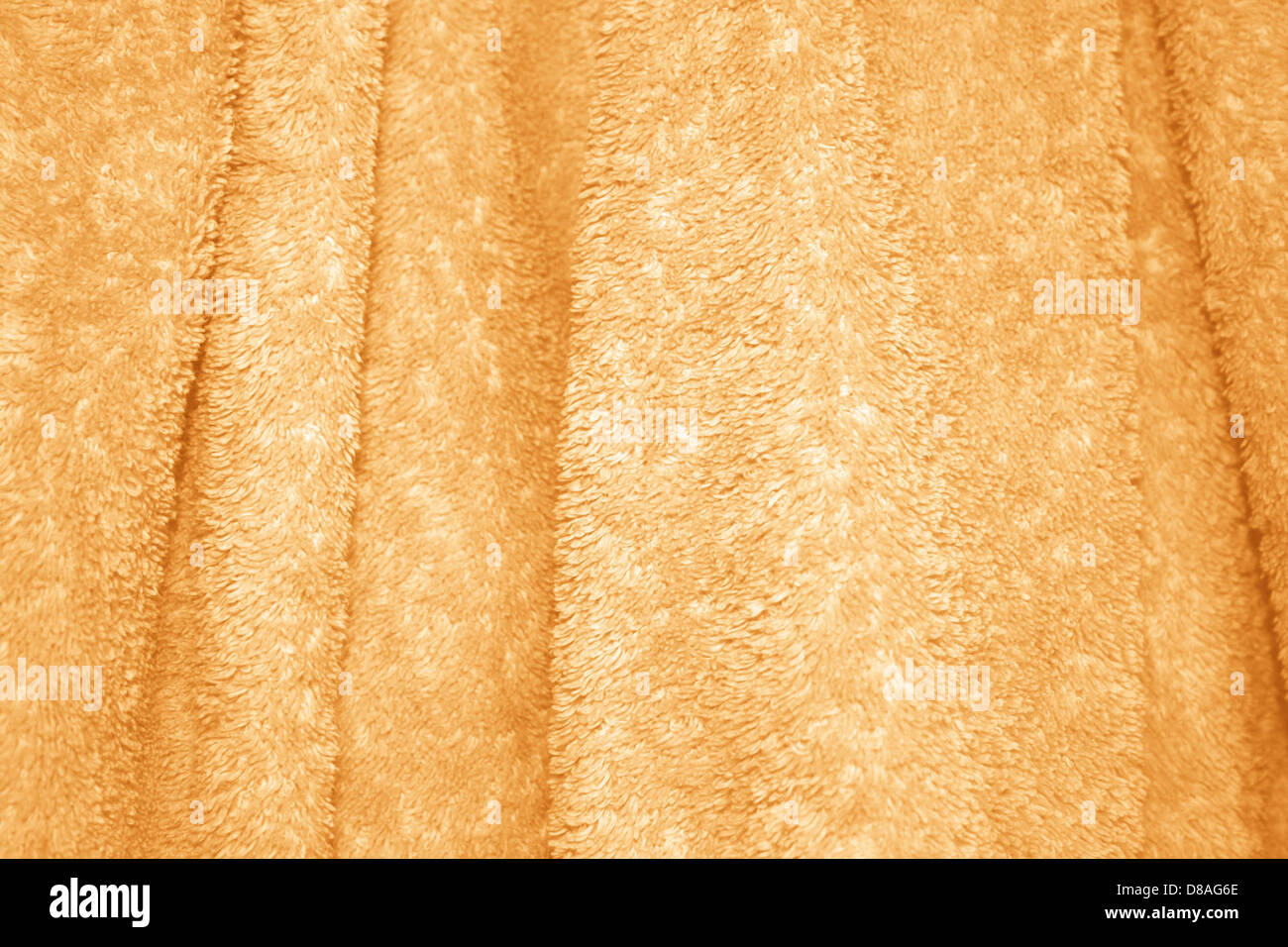 A close-up view of an orange terry cloth bath towel, showcasing its ...