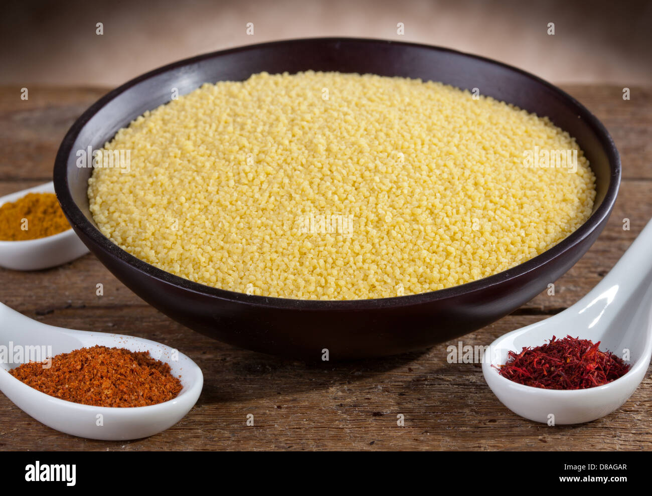 Raw Couscous in a wooden bowl with spices Stock Photo - Alamy