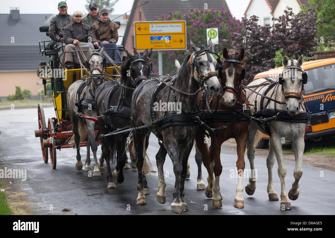 A seven horse-drawn stagecoach goes along a road between Parchim and ...