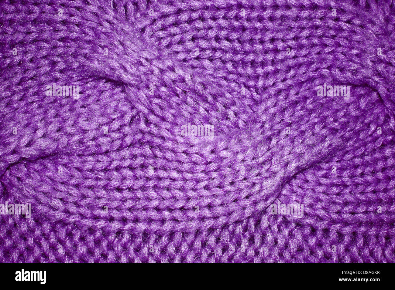 A close-up view of a purple cable knit fabric texture. The interwoven ...
