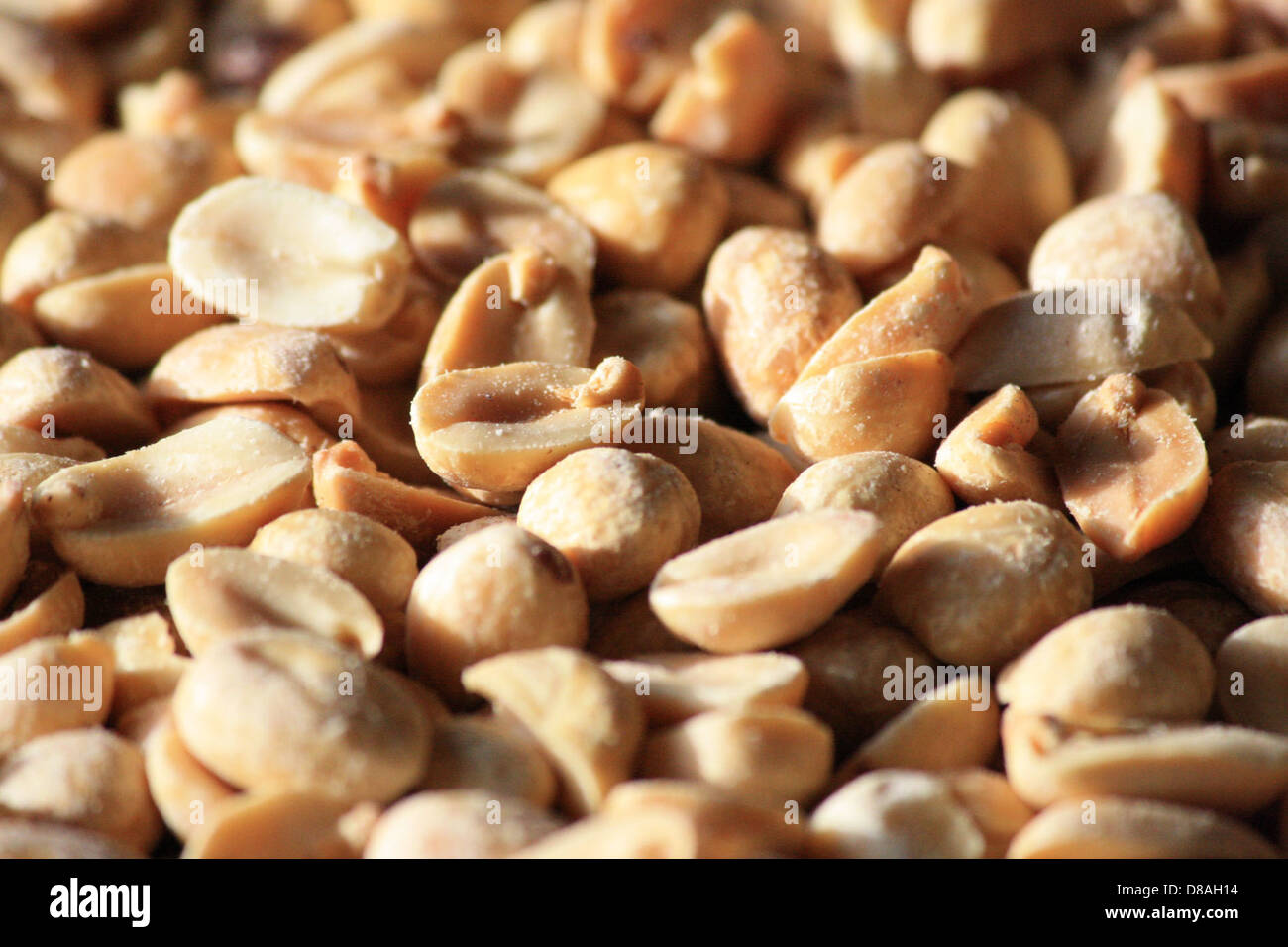 The image shows roasted peanuts, showcasing their golden-brown color ...