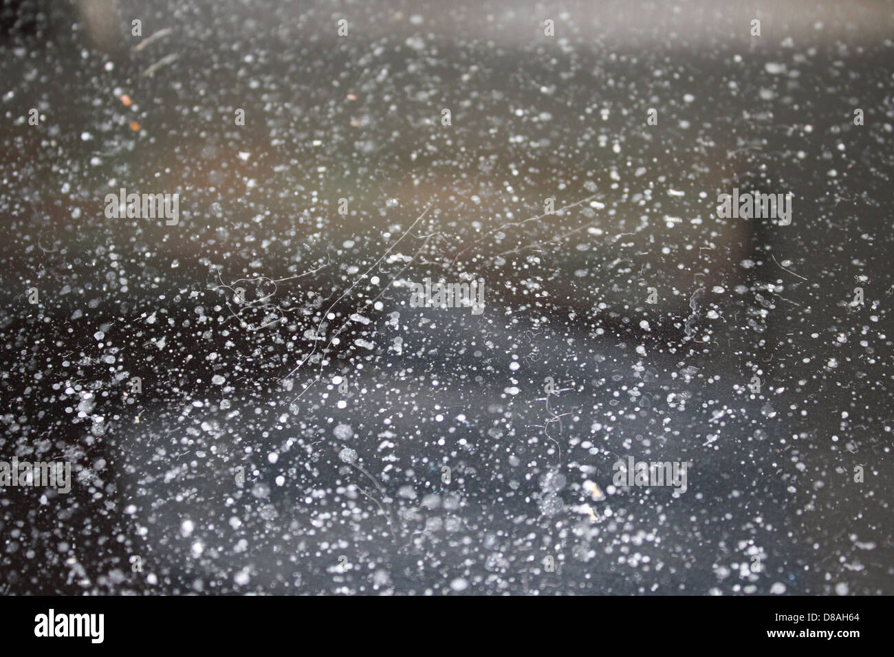 A dirty mirror with visible spots and smudges, providing a textured ...