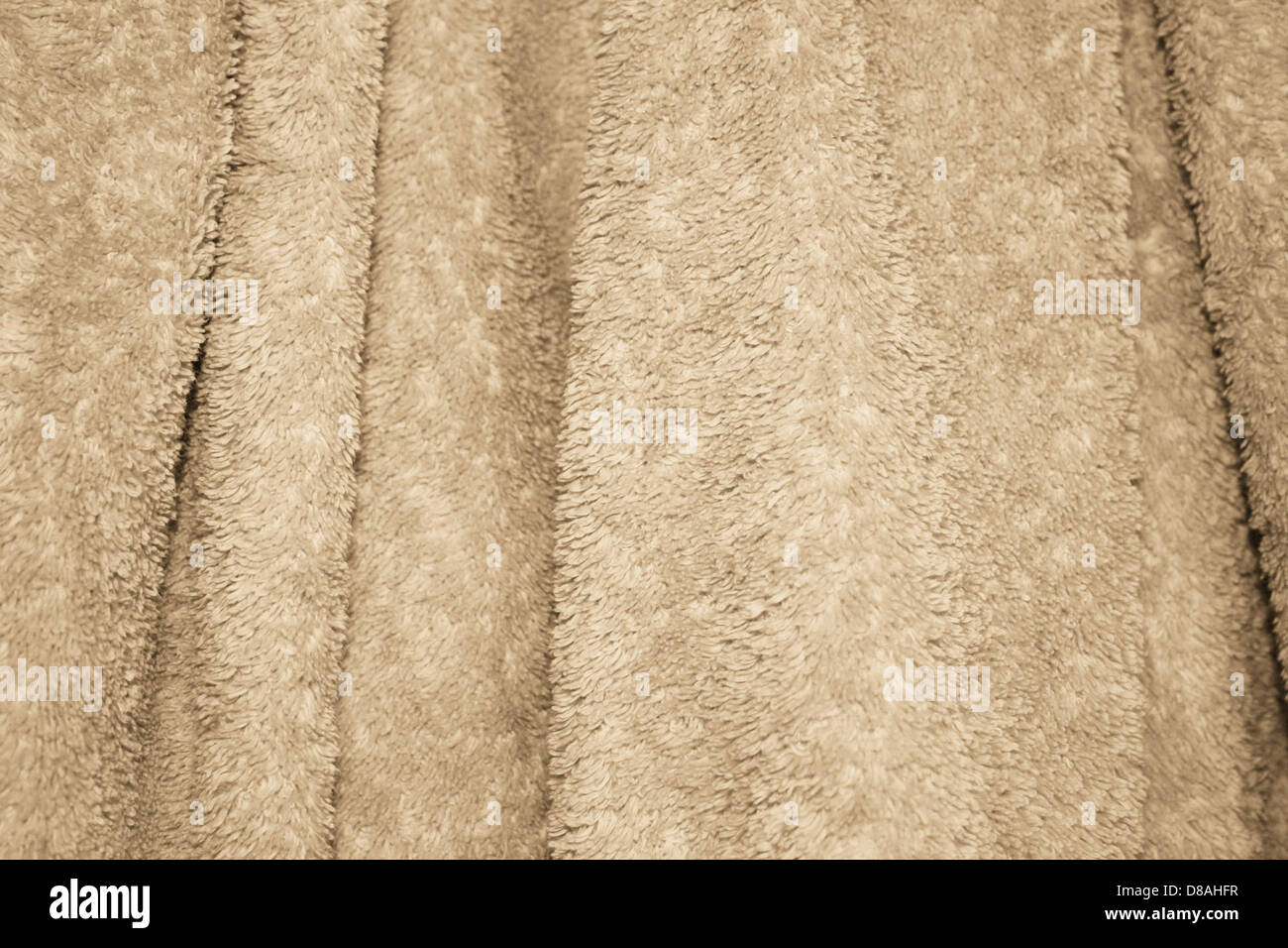 Close-up view of a tan terry cloth bath towel, highlighting the plush ...