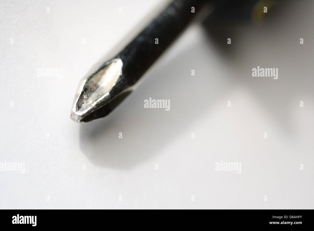 A close-up view of the tip of a Phillips head screwdriver. The image ...