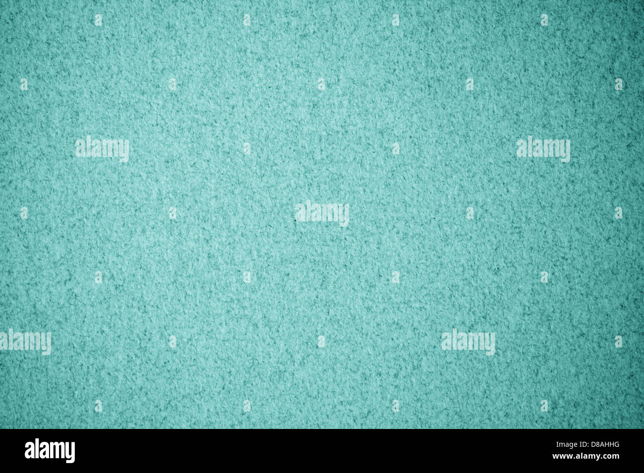 A textured sheet of teal-colored paper with speckled patterns. The ...