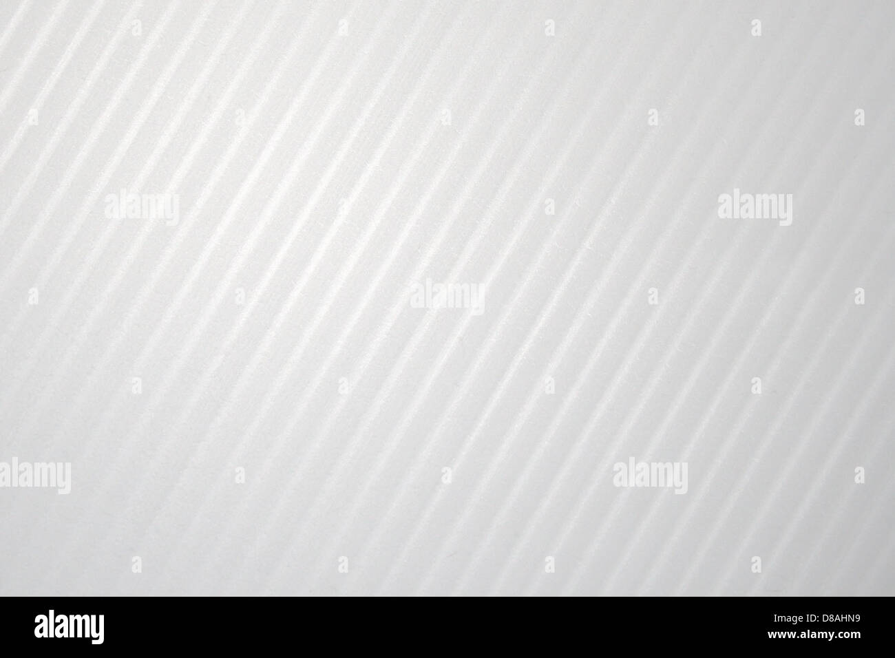A close-up view of a white plastic surface with diagonal stripes ...