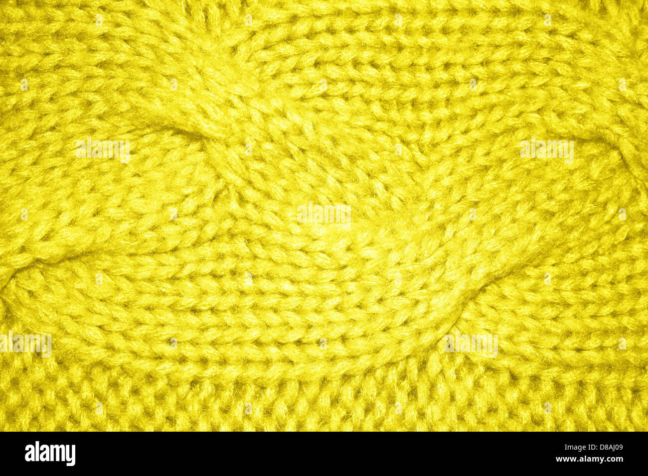 A close-up of a yellow cable knit fabric, highlighting the intricate ...