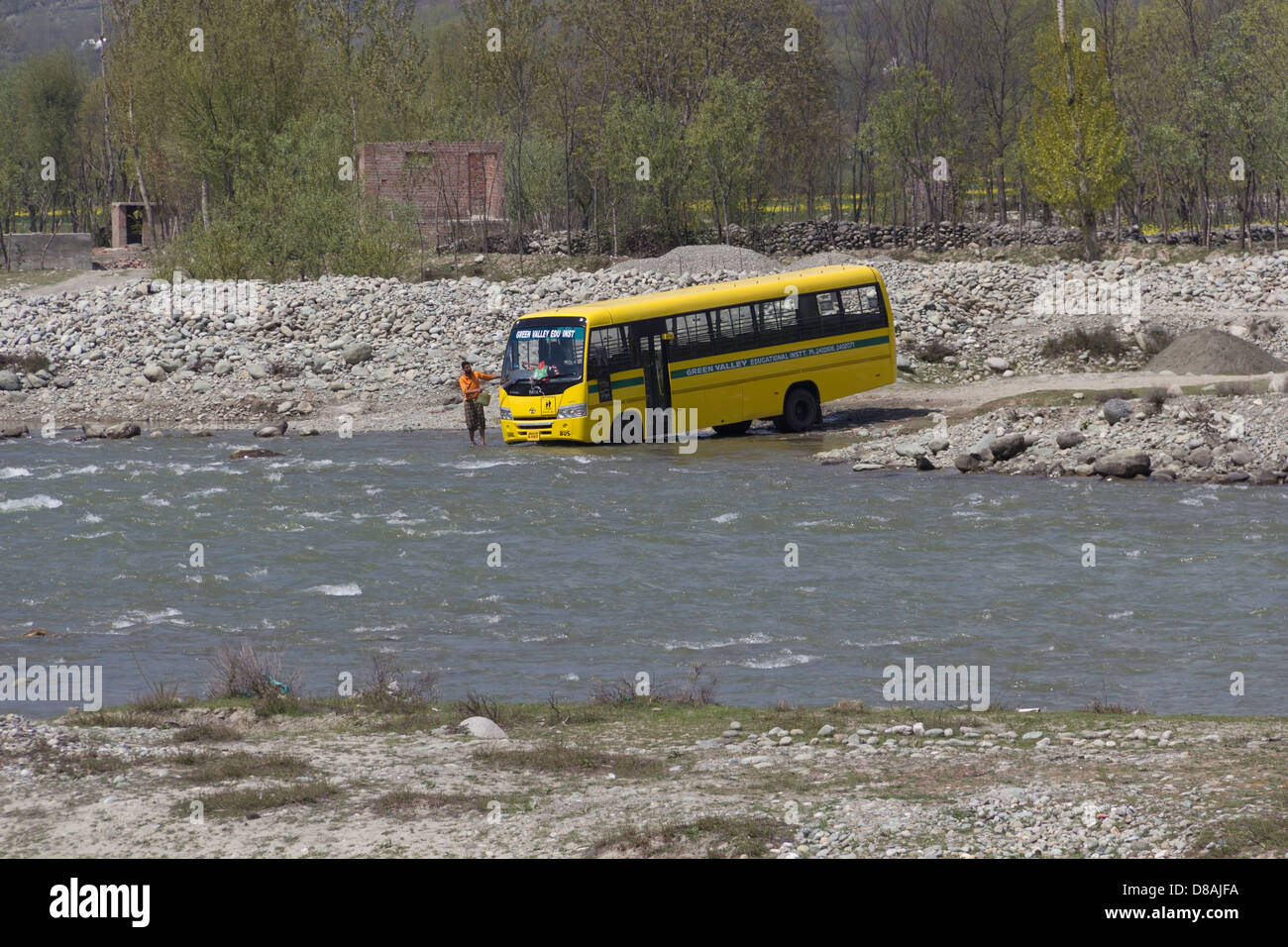 Man cleaning school bus using water of a mountain stream on the ...