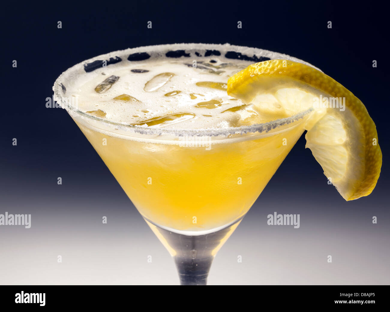 Glass with yellow cocktail and lemon, alcoholic drink of orange juice ...