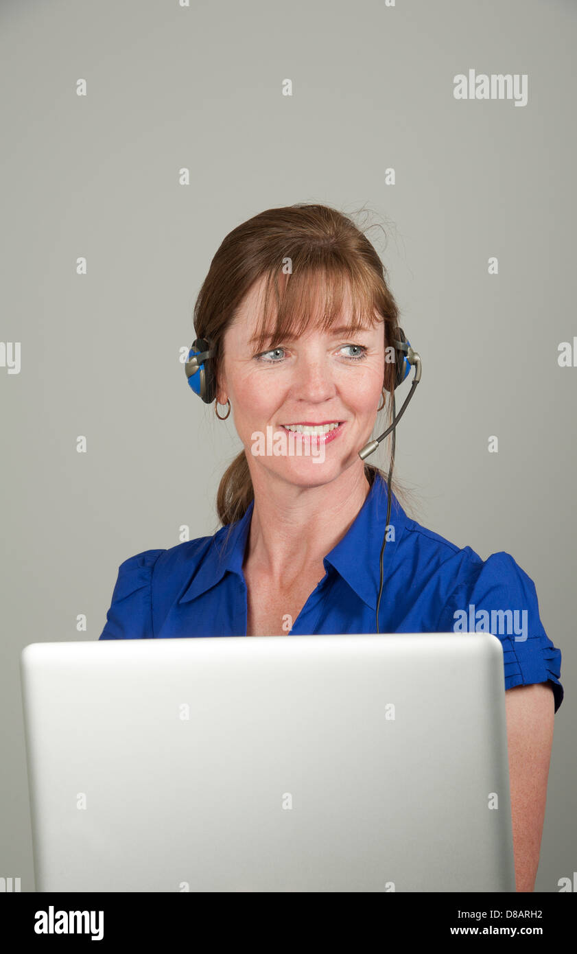 Woman using a headset and computer Stock Photo - Alamy