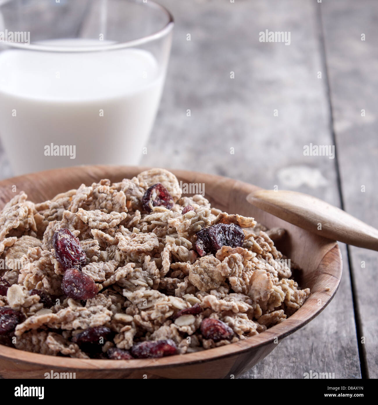A bowl of cereal with cranberries and glass of milk on the table Stock ...