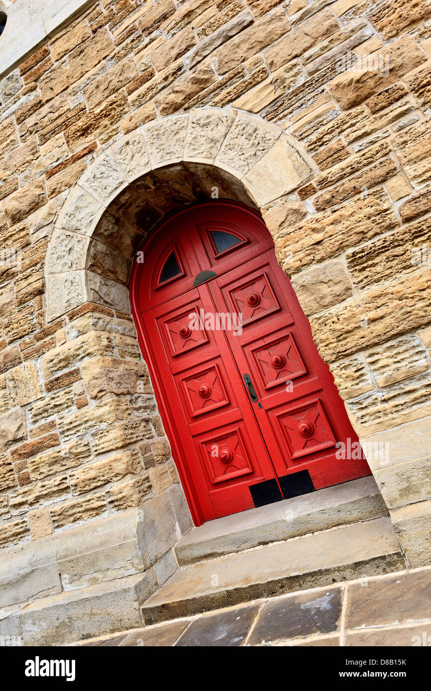 Red door in stone building Stock Photo - Alamy