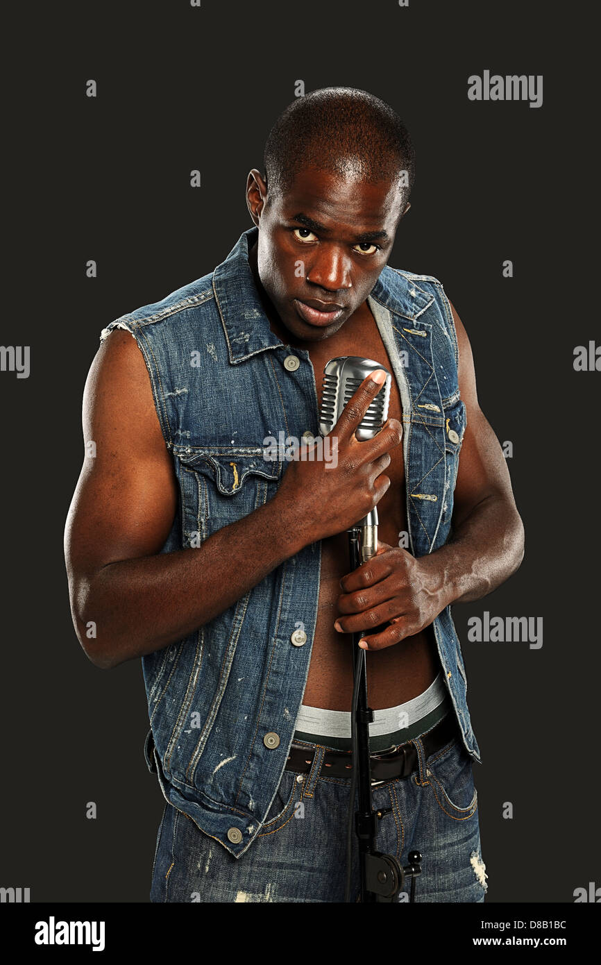 Young African American Singer holding a vintage microphone isolated on ...