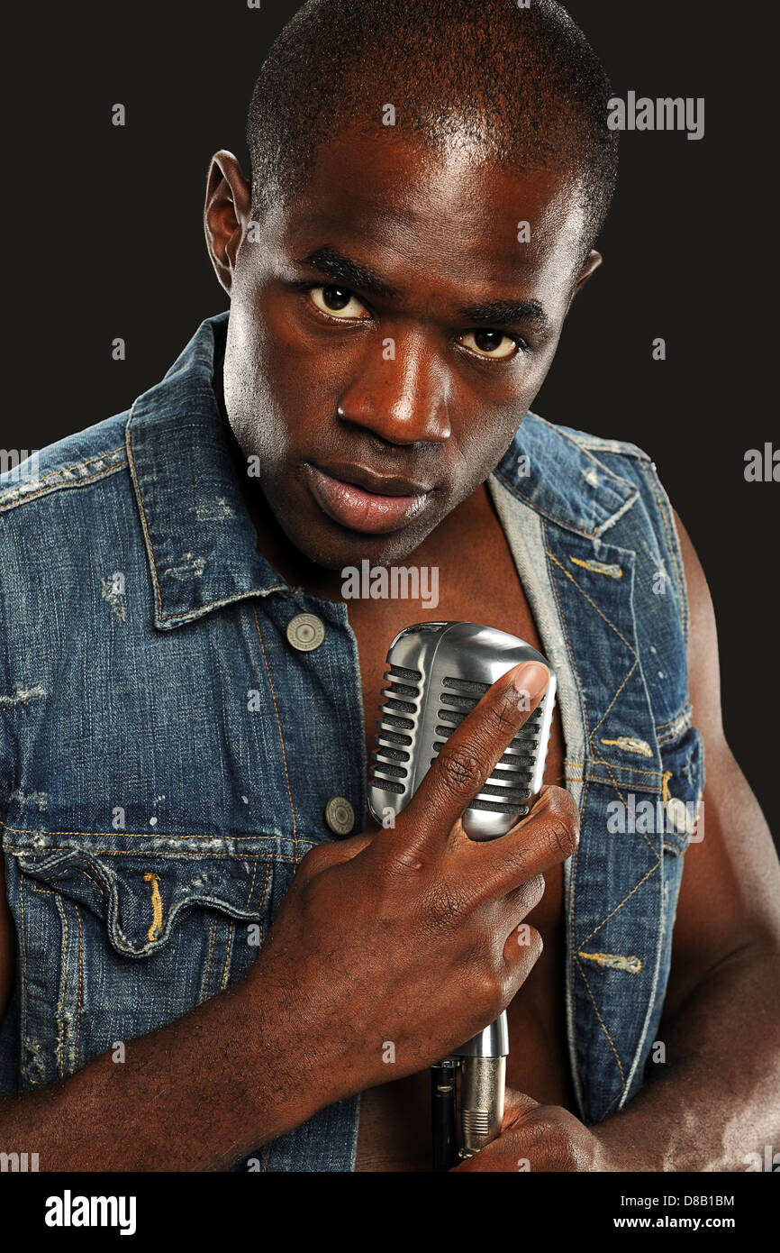 Young African American Singer holding a vintage microphone isolated on ...
