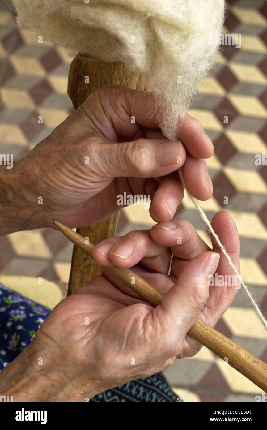Old hands spinning wool. Selective focus on hand Stock Photo - Alamy