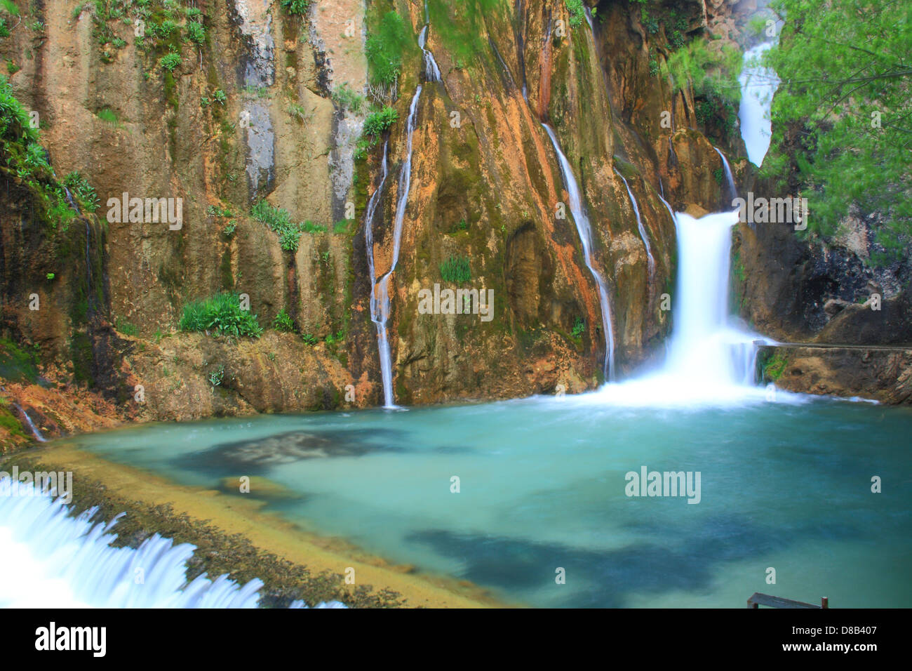 water falling to river between huge rocks Stock Photo - Alamy