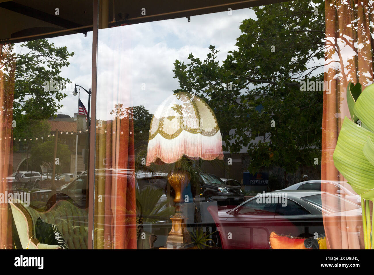 Street scene reflected in the window of a shop selling antique ...