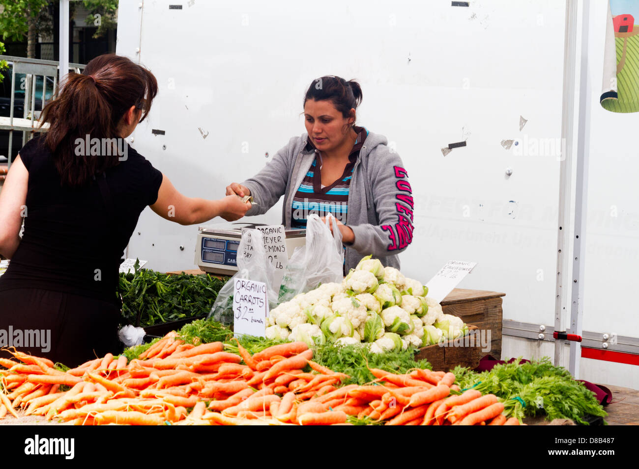 Woman buying produce from a vendor at a farmers' market Stock Photo - Alamy