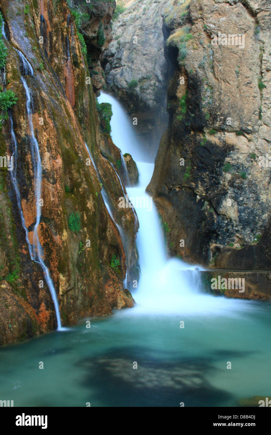 water falling to river between huge rocks Stock Photo - Alamy