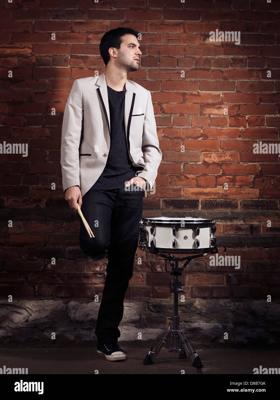 Dramatic portrait of a young man drummer with a snare drum and ...