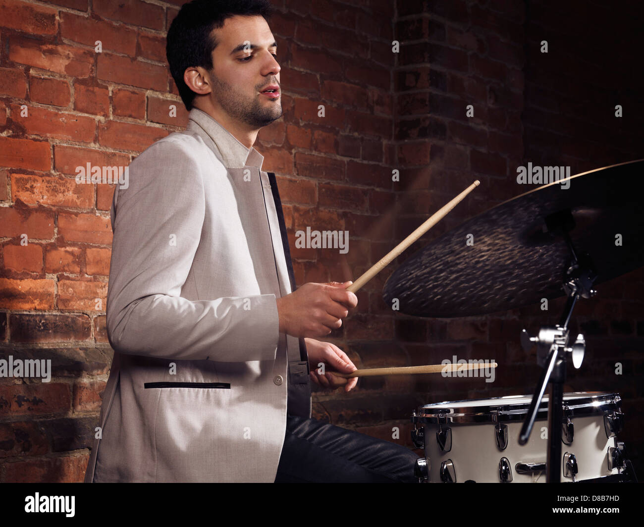 Young man musician playing drums, expressive portrait of a drummer ...