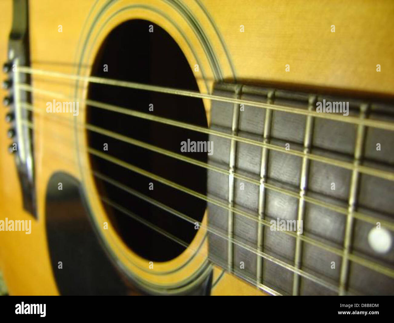 A close-up photo of an acoustic guitar, highlighting its natural wood ...