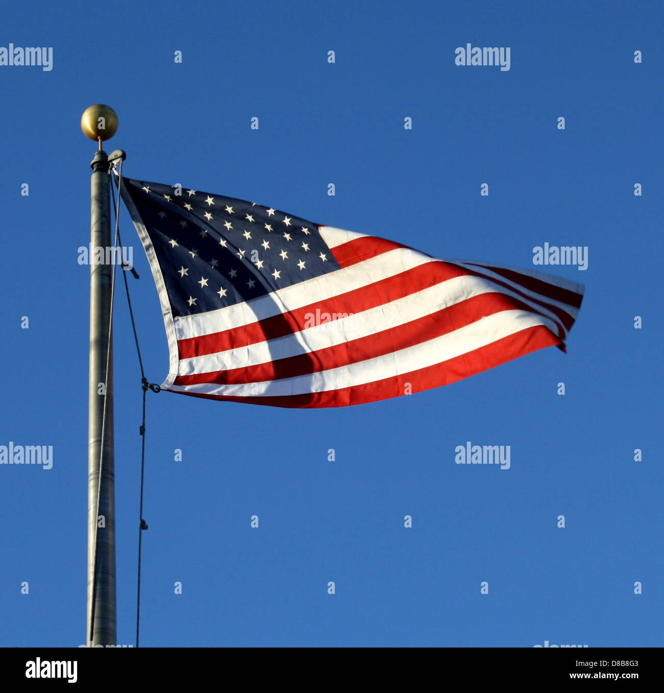 This image shows the American flag flying proudly on a flagpole against ...