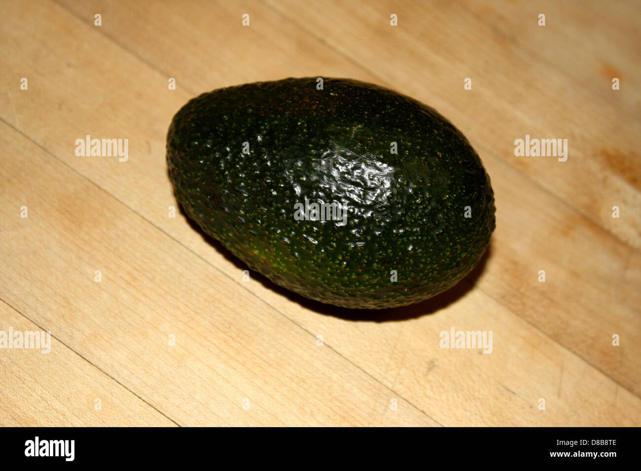 A ripe avocado, showcasing its smooth green skin and large pit at the ...