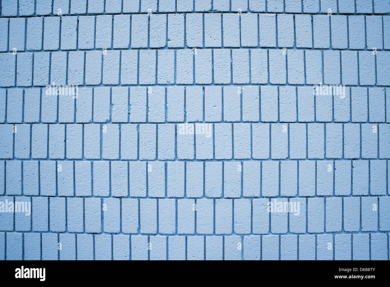 A close-up image of a baby blue brick wall with vertical bricks ...