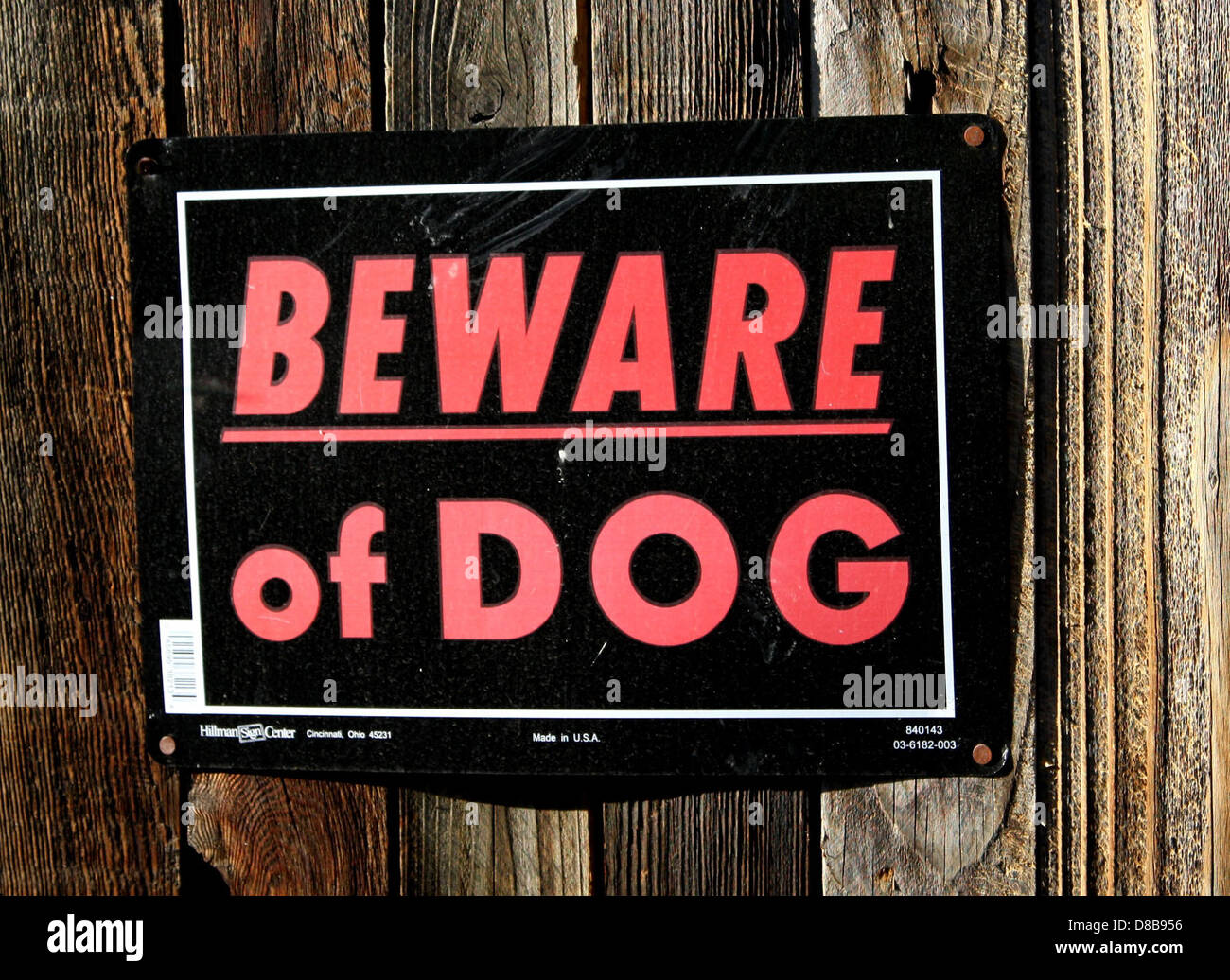 A red warning sign featuring a 'Beware of Dog' message. The sign is ...