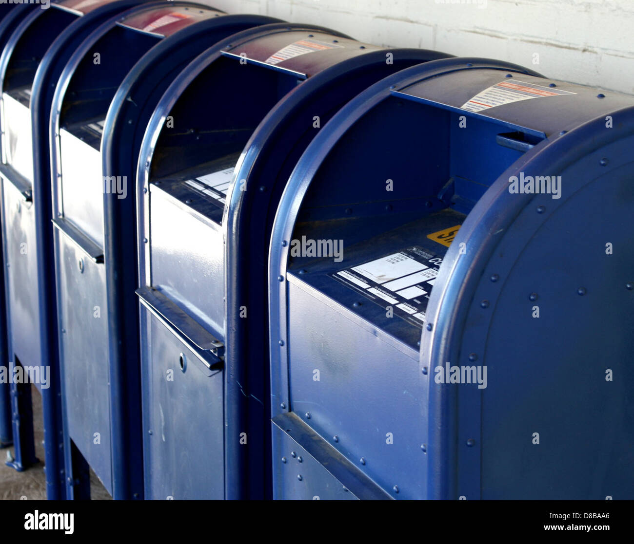 A collection of blue mailboxes lined up, with their vibrant color ...