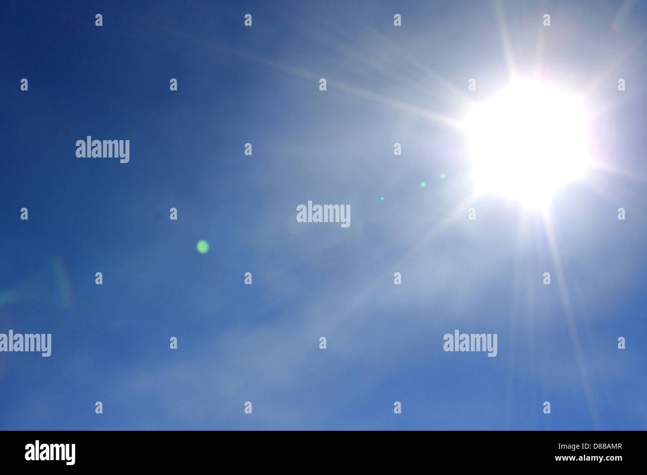 A bright sun is visible in a clear blue sky, illuminating the day. The ...