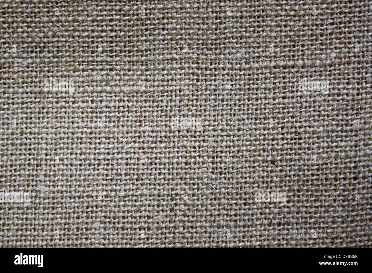 A close-up image of burlap fabric showing its woven texture. The rough ...