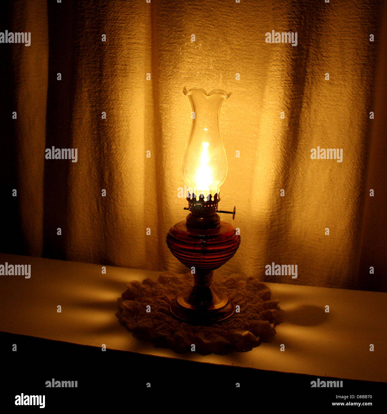 An oil lamp burning brightly, casting a warm glow. The image captures ...
