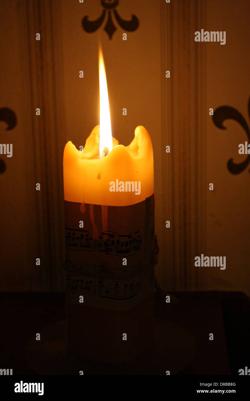 A tall flame burning from a candle, creating a warm, cozy ambiance ...