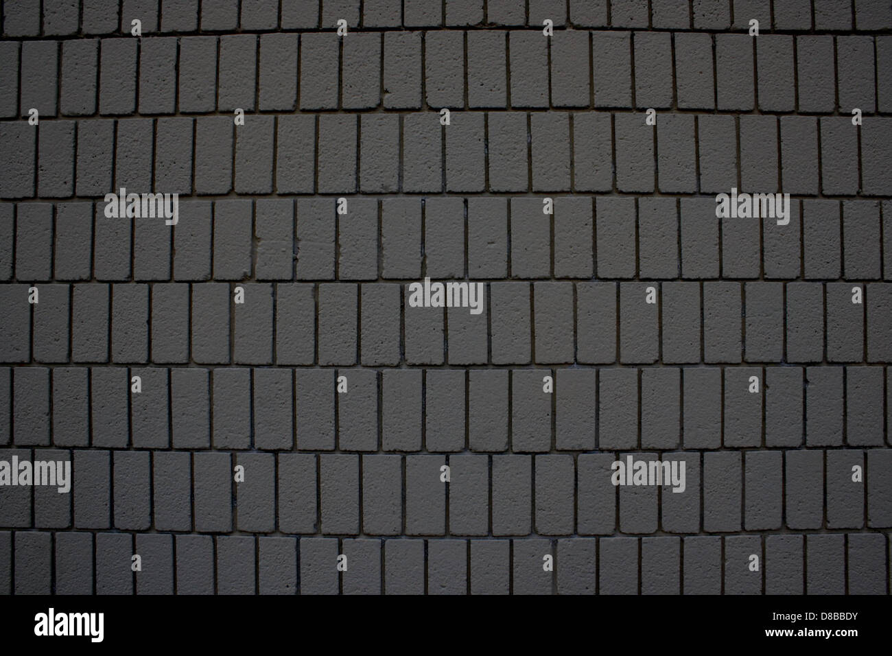 A close-up view of a charcoal gray brick wall with vertical brick ...