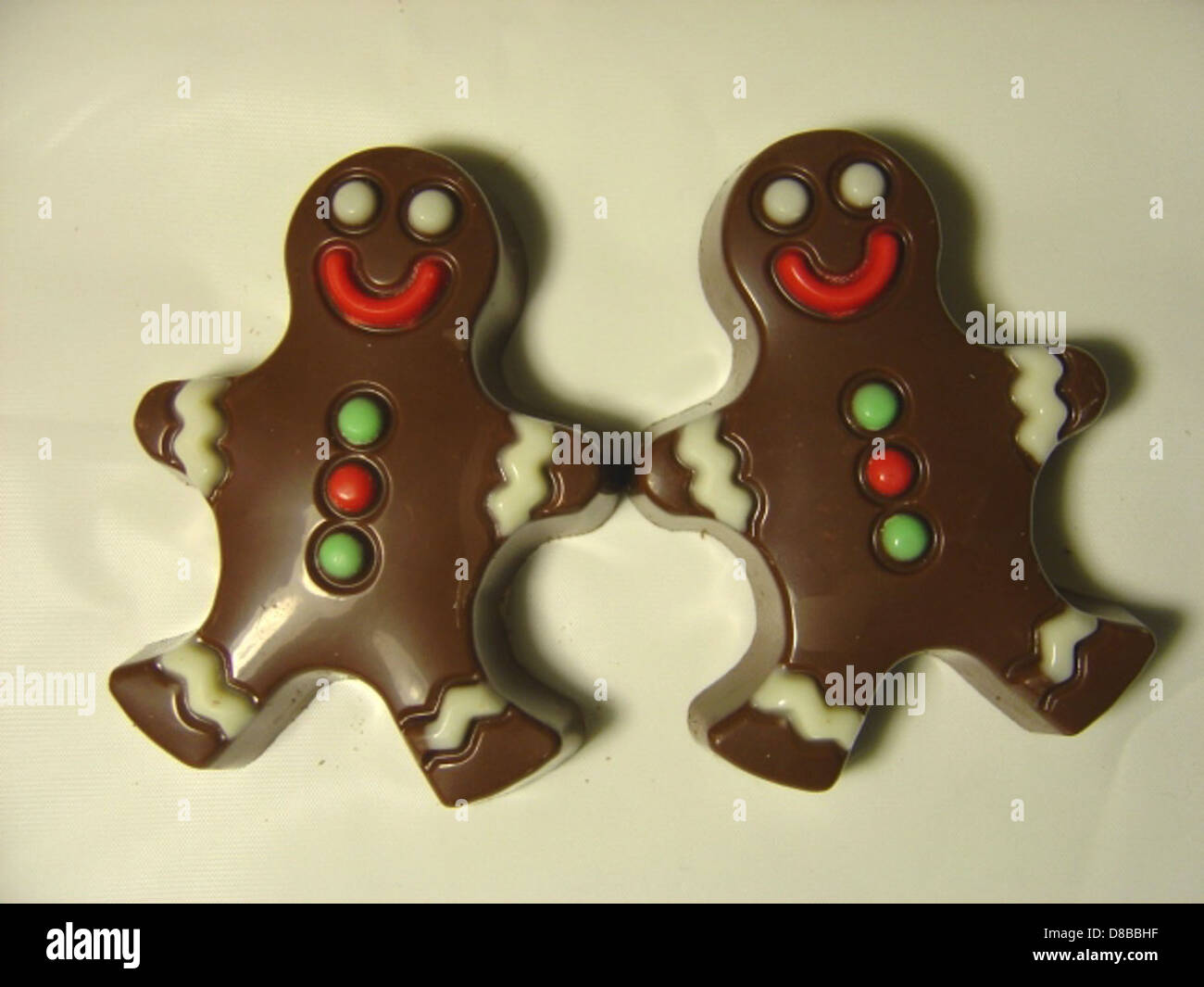 A batch of gingerbread men cookies, decorated with chocolate, sits on a ...