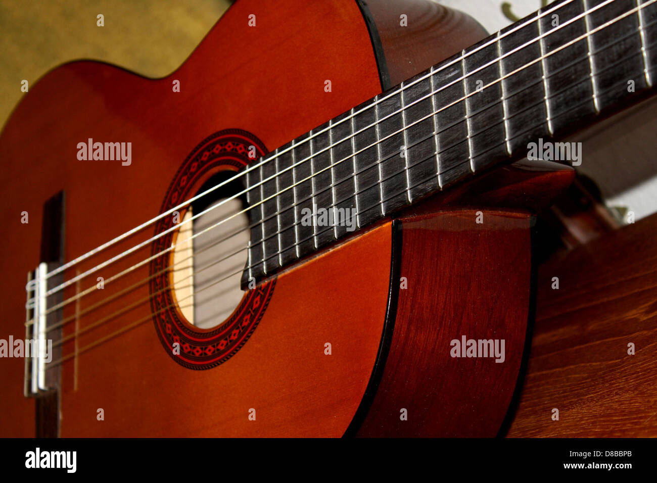 A classical guitar is shown with its wooden body and nylon strings ...