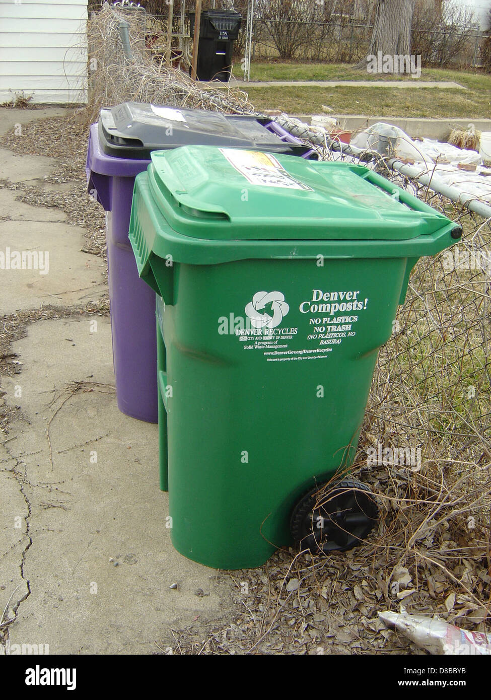 A set of compost and recycling cans placed outdoors for waste ...