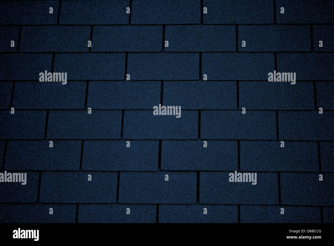 A close-up of dark blue asphalt roof shingles, showcasing their ...