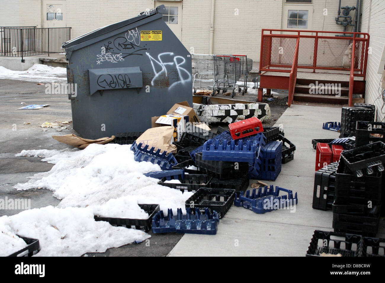 A cluttered dumpster filled with boxes and plastic crates. It reflects ...