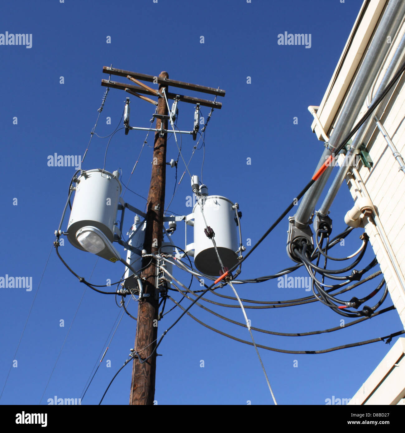 A row of electric power transformers, standing tall against the sky ...