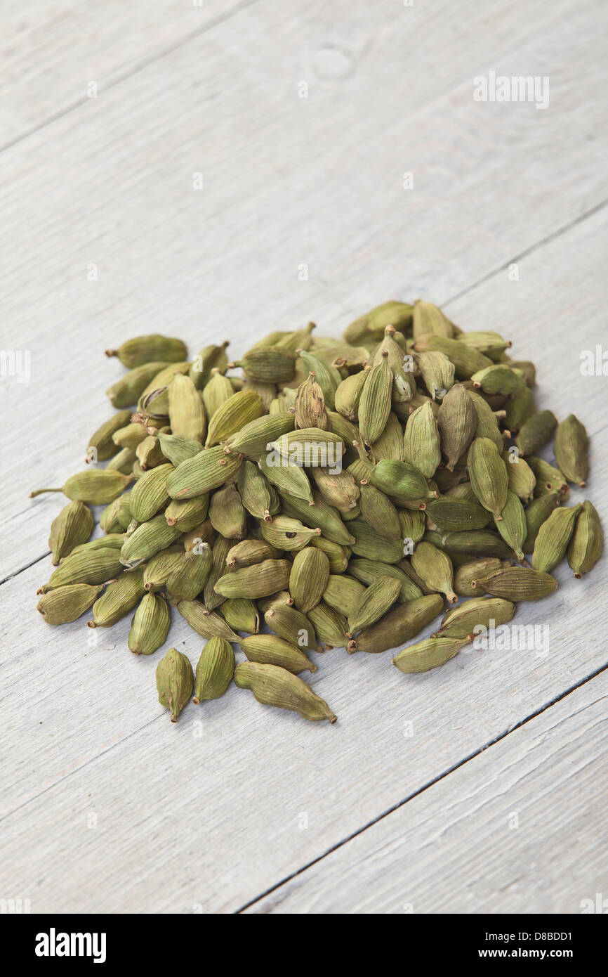 A pile of green cardamon pods on a rustic wood surface Stock Photo - Alamy