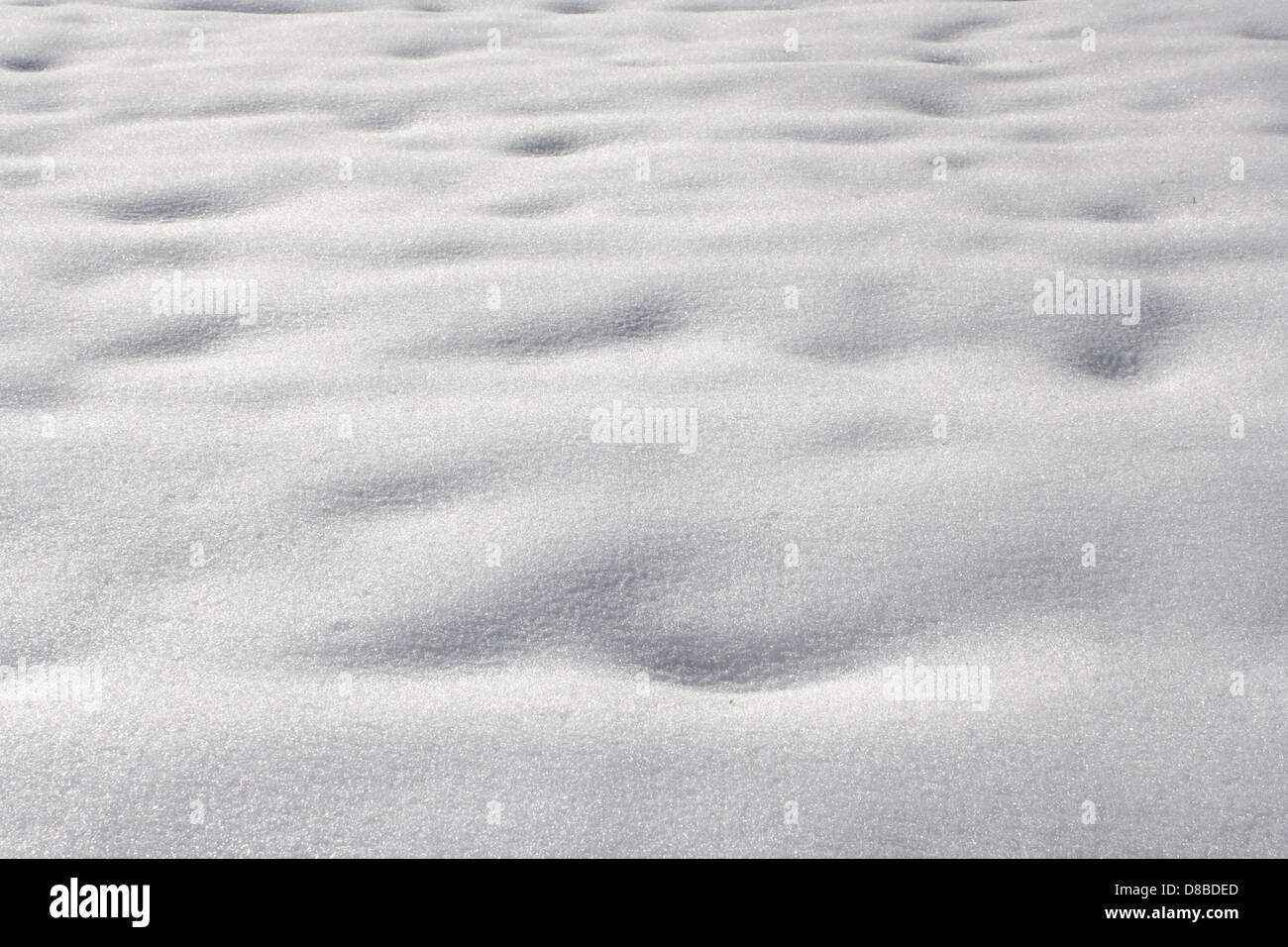 A vast field of snow with dimpled textures created by the wind or ...
