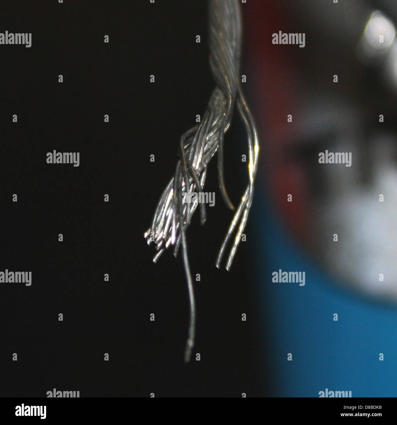 A close-up image showing the frayed end of a twisted wire cable. This ...
