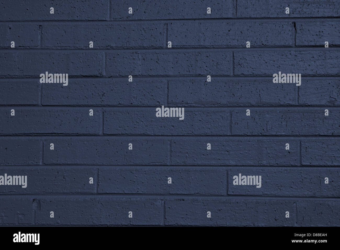 A gray-blue painted brick wall features a smooth, textured surface ...