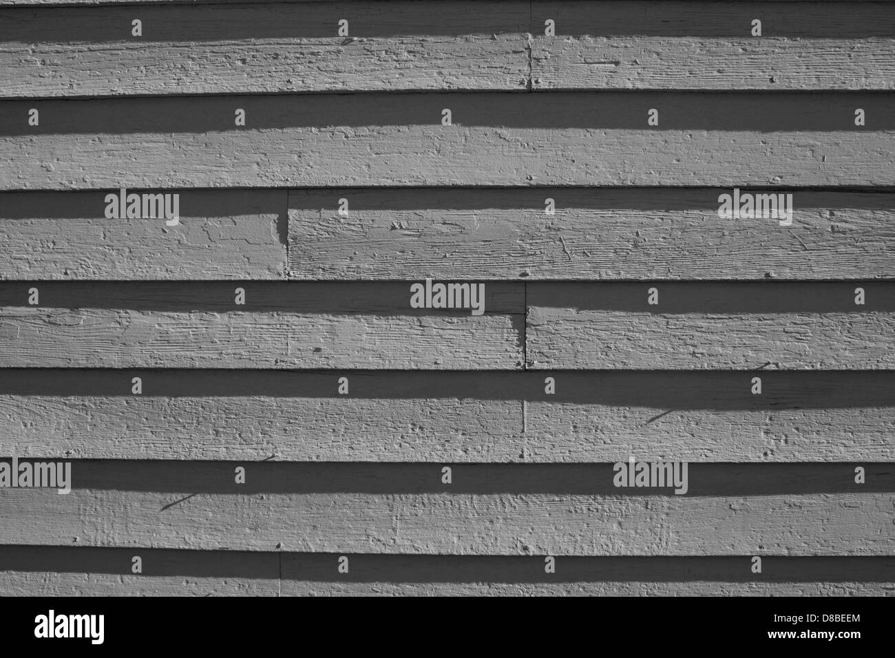 A close-up of gray-painted wooden siding, showing the smooth texture of ...